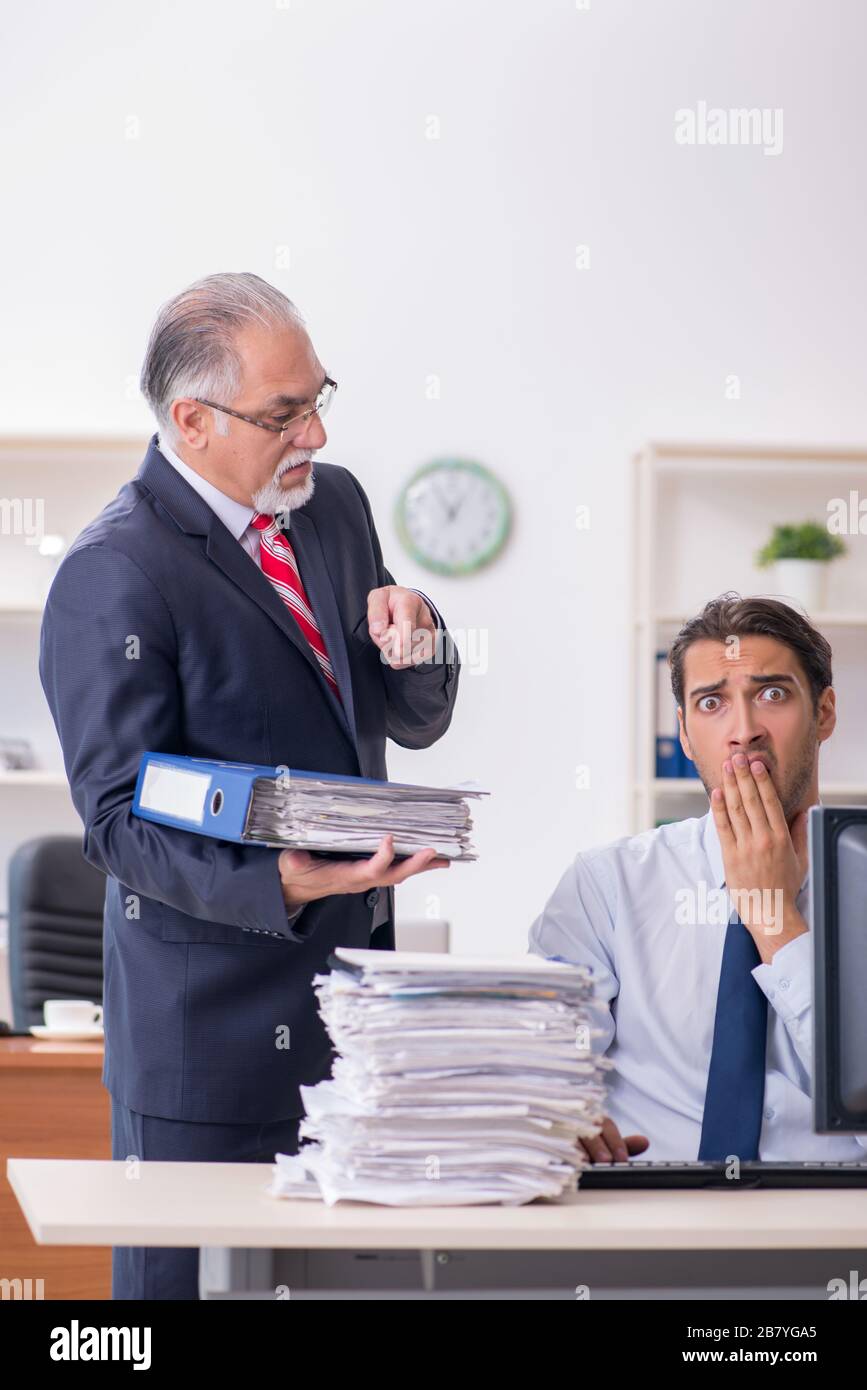 Old boss and young employee in the office Stock Photo - Alamy