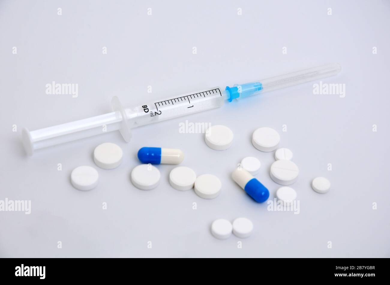 heap of medical tablets and syringe isolated on a white background ...