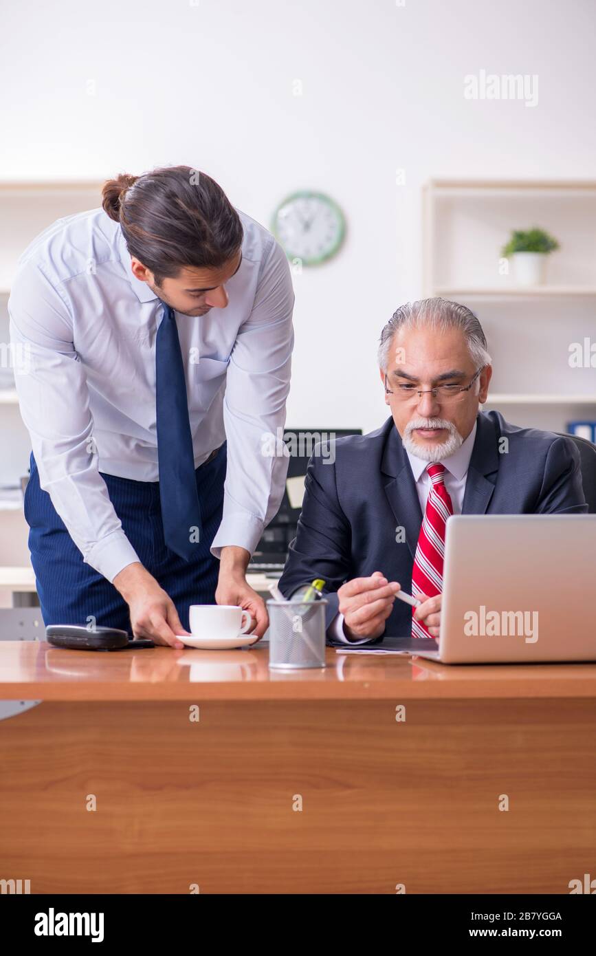 Old boss and young employee in the office Stock Photo - Alamy