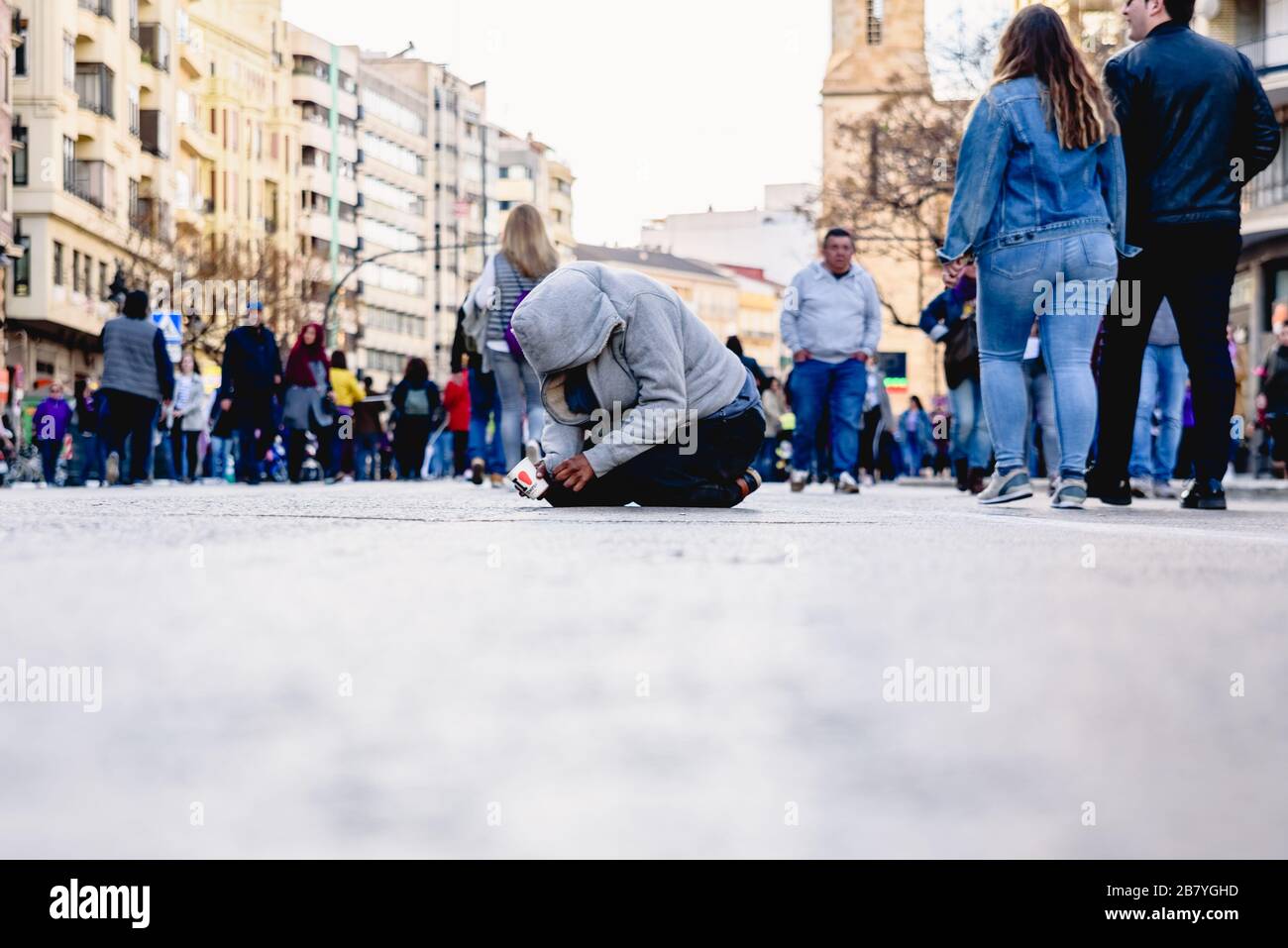 Valencia, Spain - March 8, 2020: Young beggar kneeling and crouching in ...