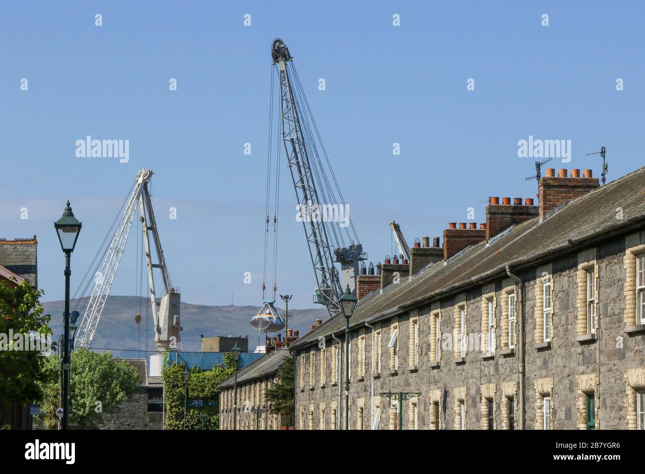 Harbour cranes above a row of Victorian terrace houses built for dock ...