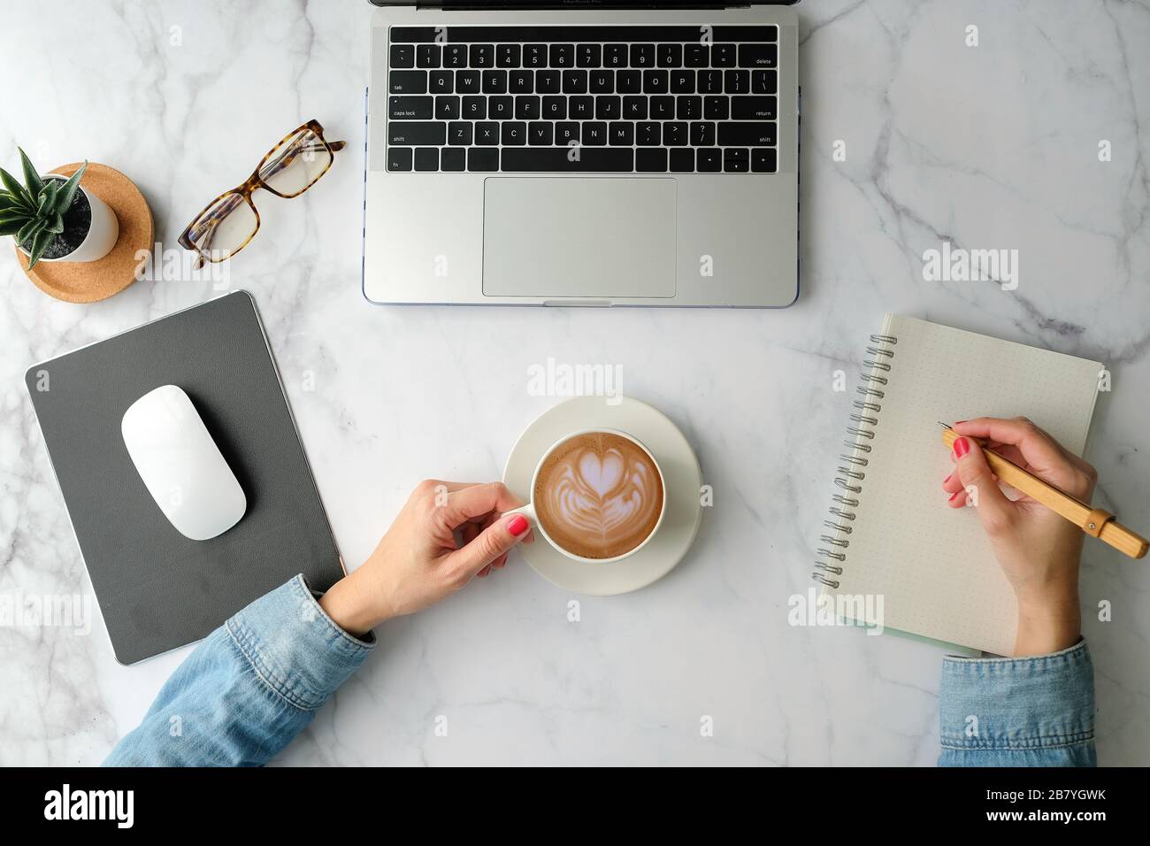 Flat lay workspace. Woman hand with coffee cup, smartphone, computer ...