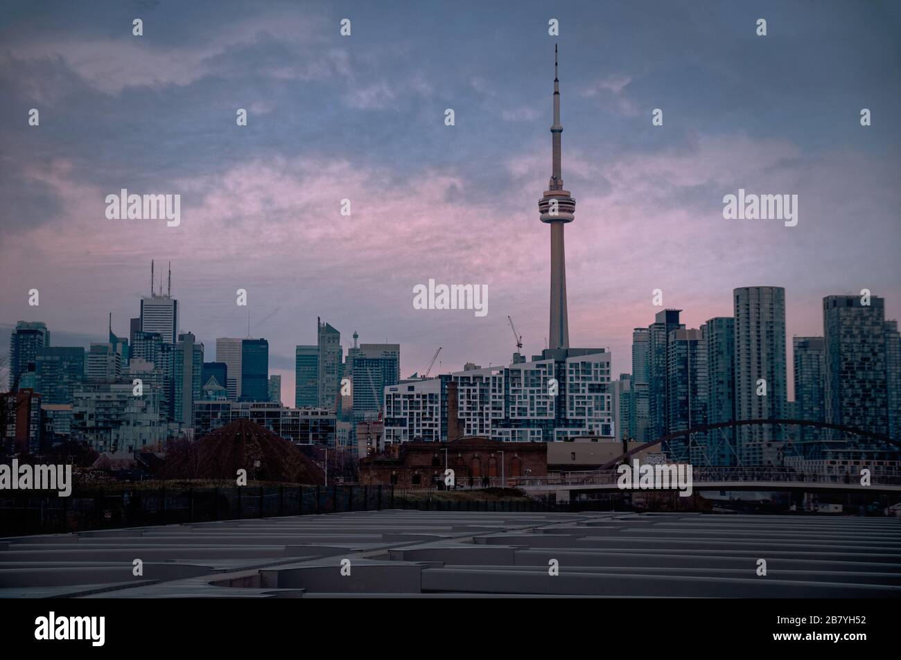 CN tower spire piercing menacing sky with dark clouds in dusk in ...