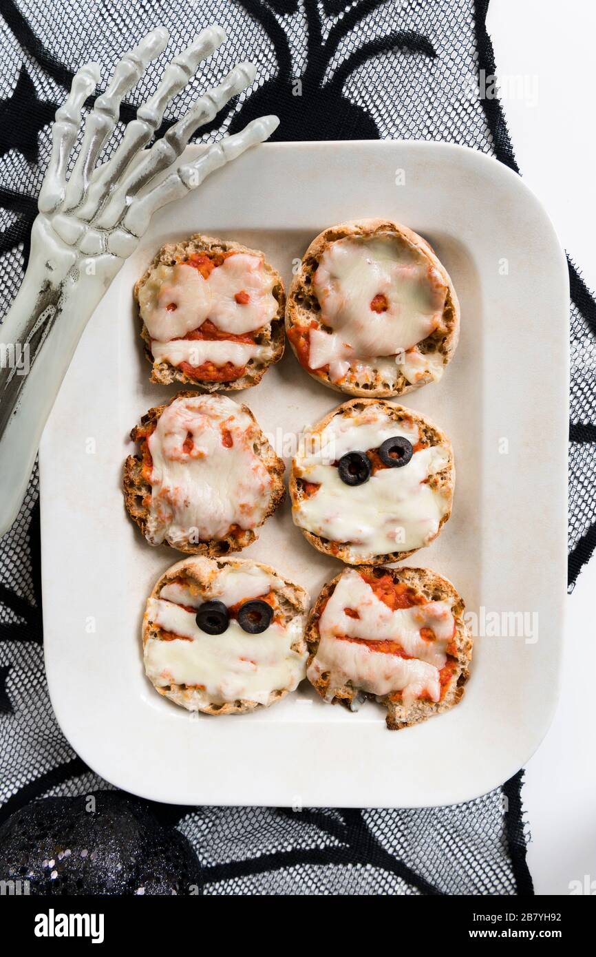 Plate of mini pizzas and hand of Halloween skeleton Stock Photo - Alamy