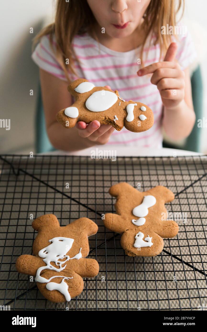 Girl eating gingerbread man Stock Photo - Alamy
