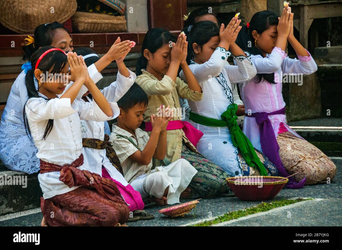 Children and other family members praying at their home in traditional ...
