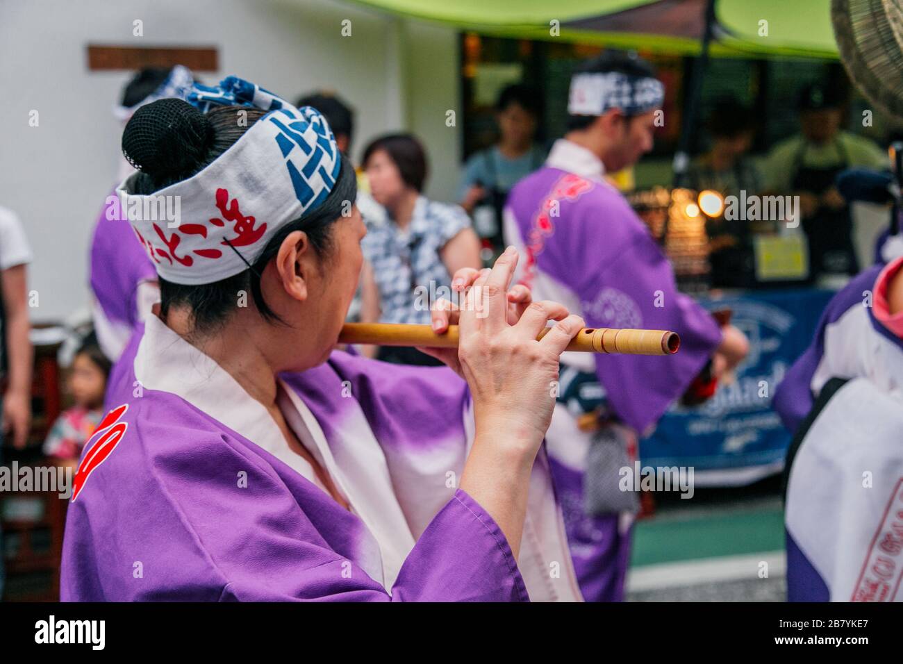Woman playing Japanese traditional music instrument at summer festival ...
