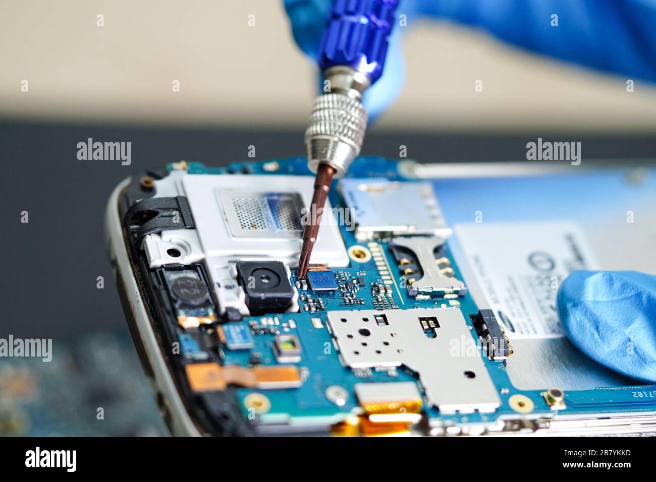 Asian Technician repairing micro circuit main board of smartphone ...
