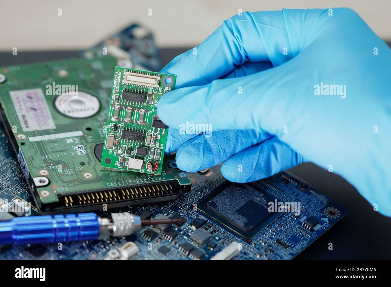 Asian Technician repairing micro circuit main board computer electronic ...