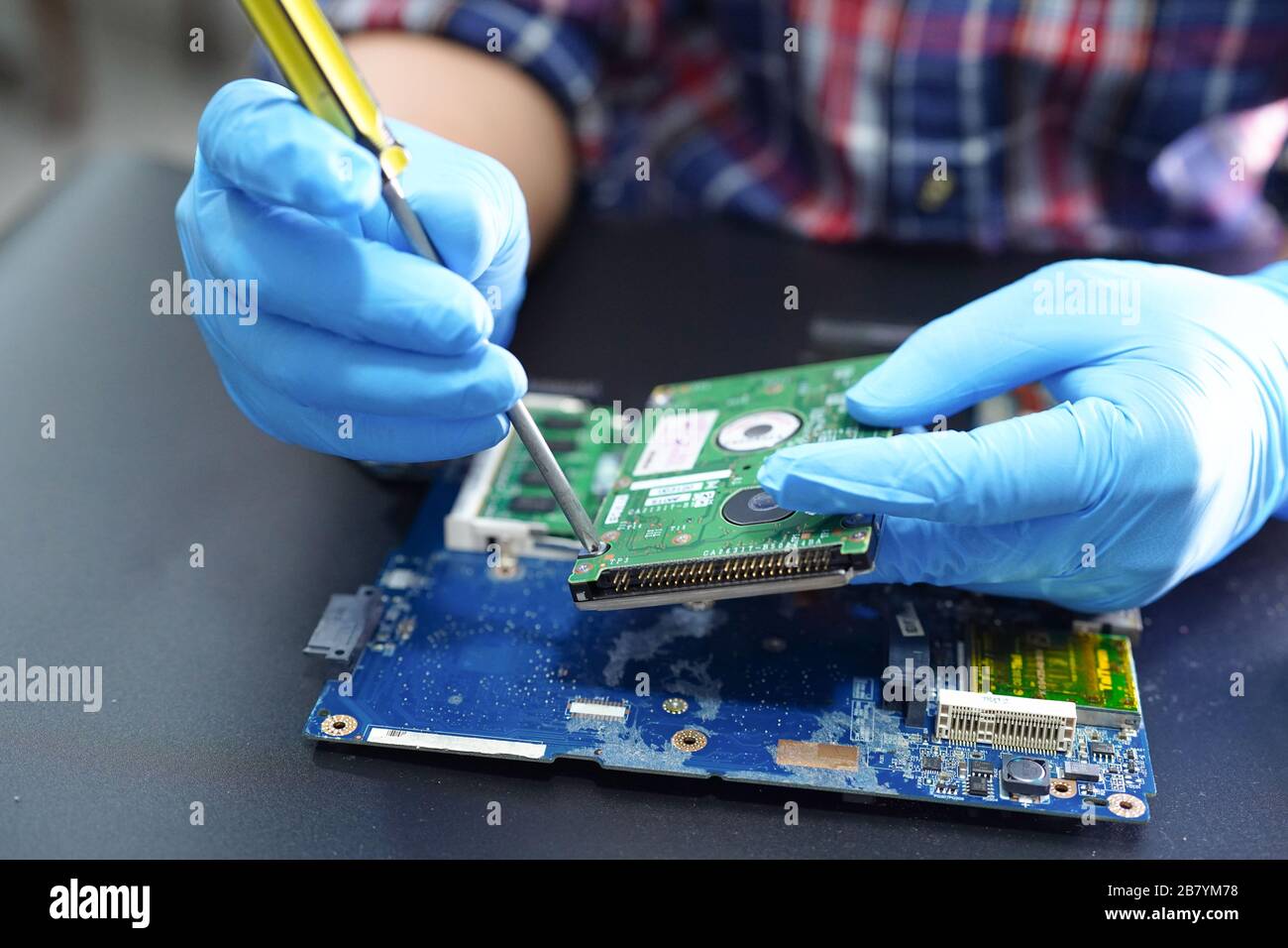 Asian Technician repairing micro circuit main board computer electronic ...