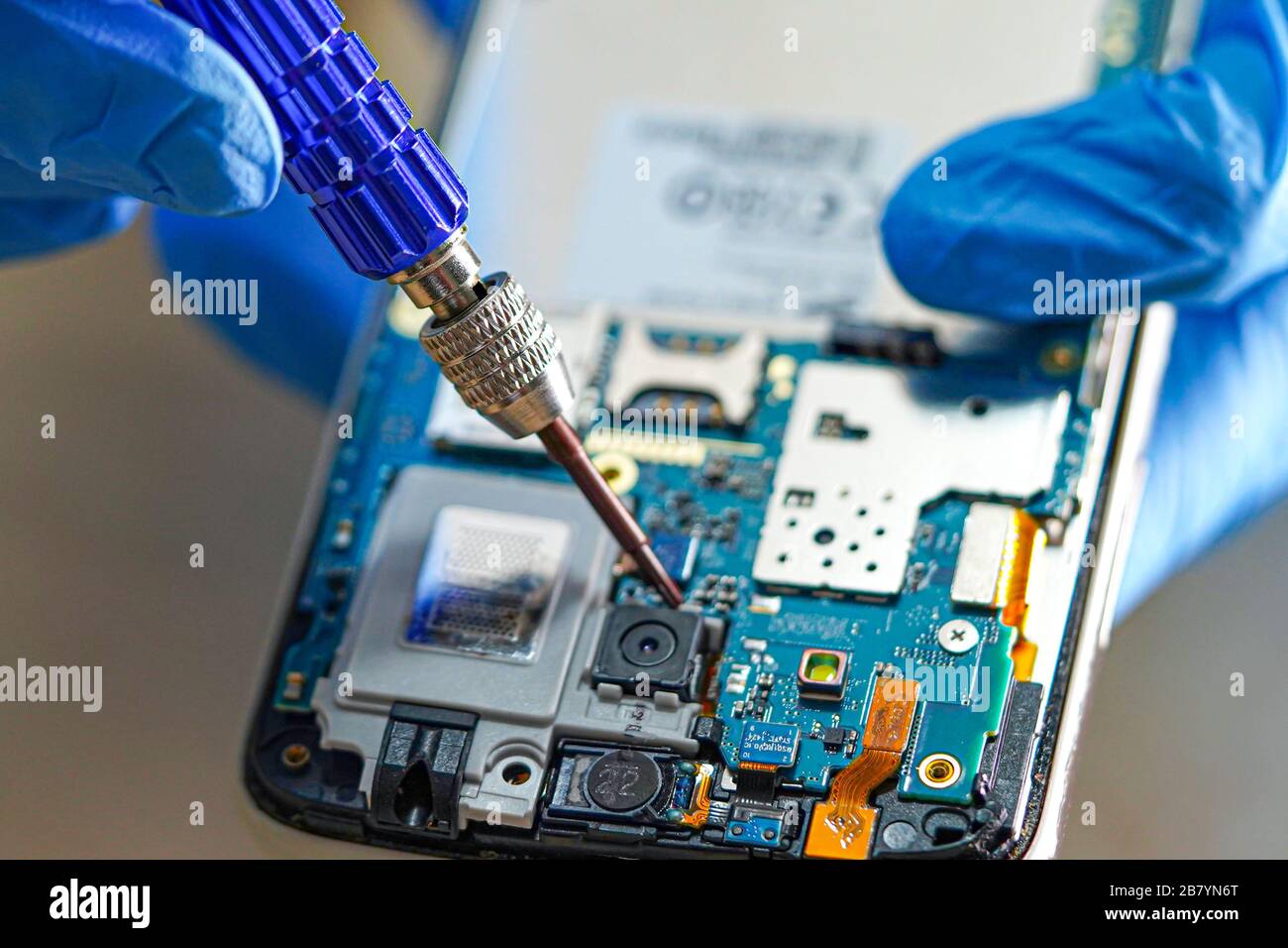 Asian Technician repairing micro circuit main board of smartphone ...