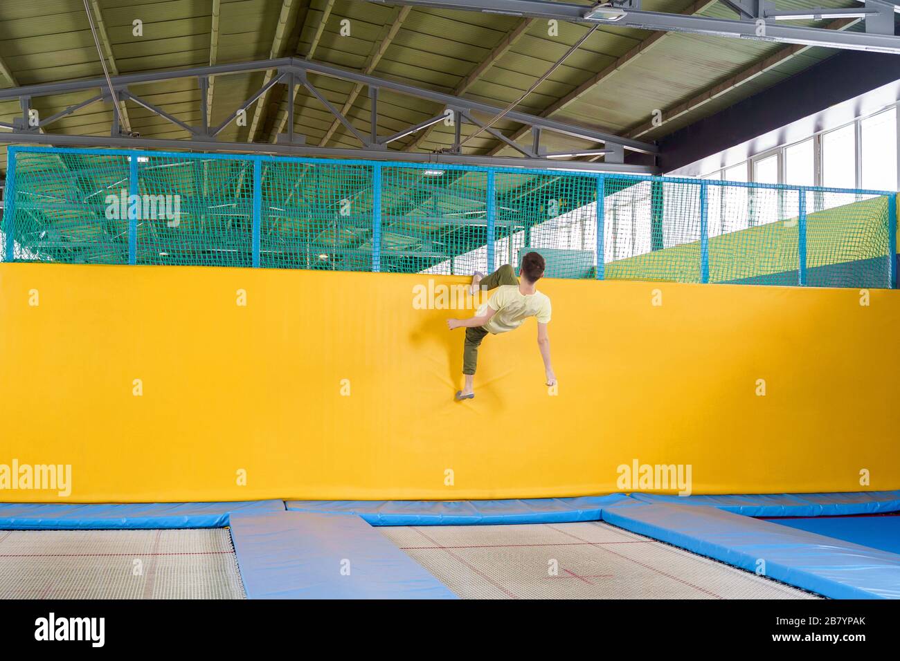 Teenage boy jumping on trampoline park in sport center Stock Photo - Alamy