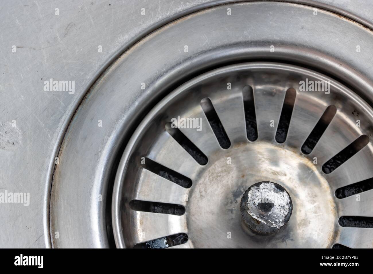 A metal sink with drain hole, macro view. Mechanically adjustable drain ...
