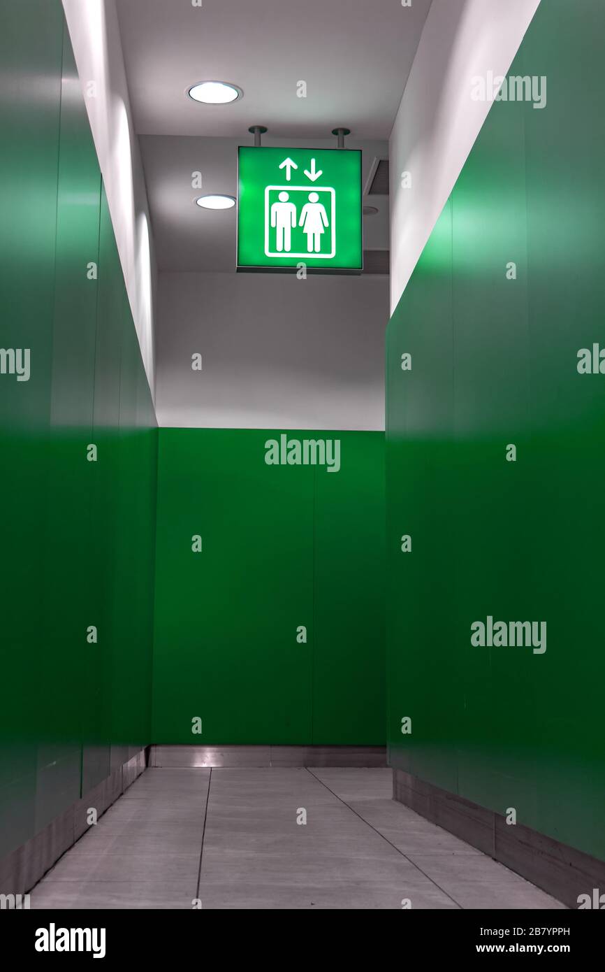 An illuminated sign with the icon of a lift hang on ceiling of the ...
