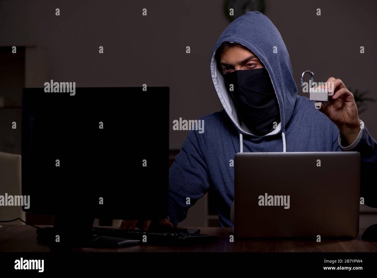 Male hacker hacking security firewall late in the office Stock Photo ...