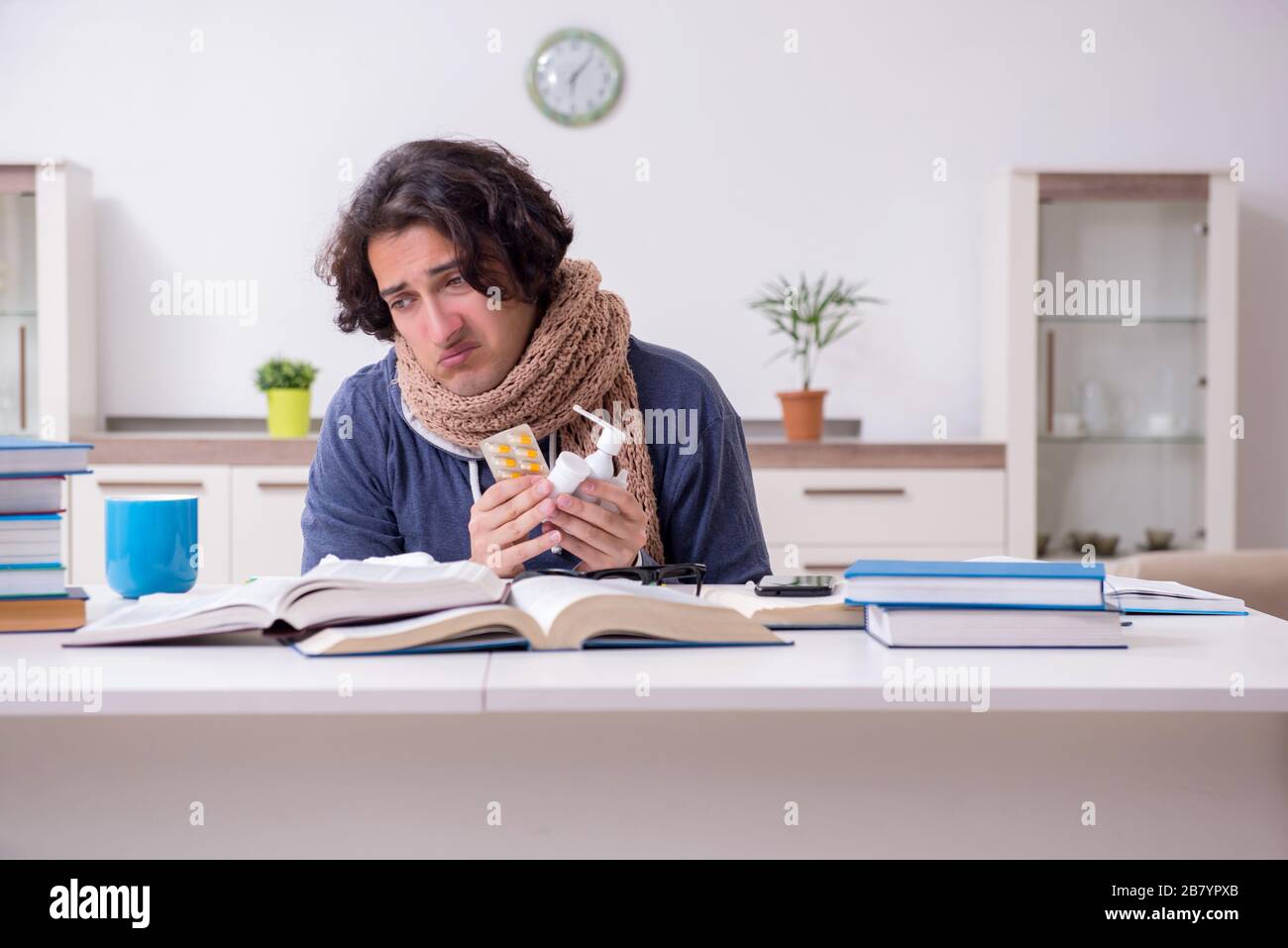 The sick male student suffering at home Stock Photo - Alamy