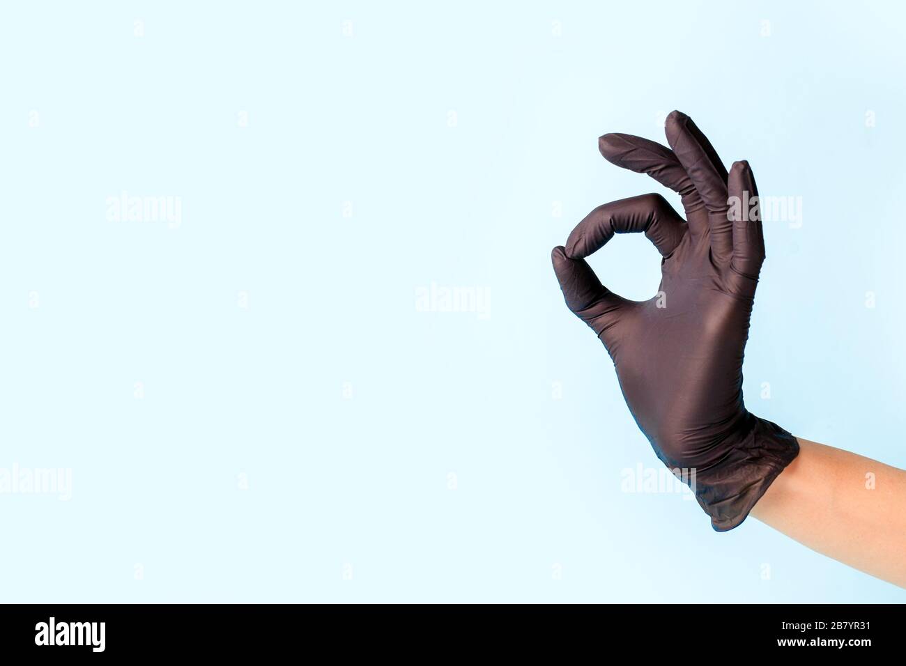 Female hand in cosmetology medicine black glove pointing up okay, yes ...