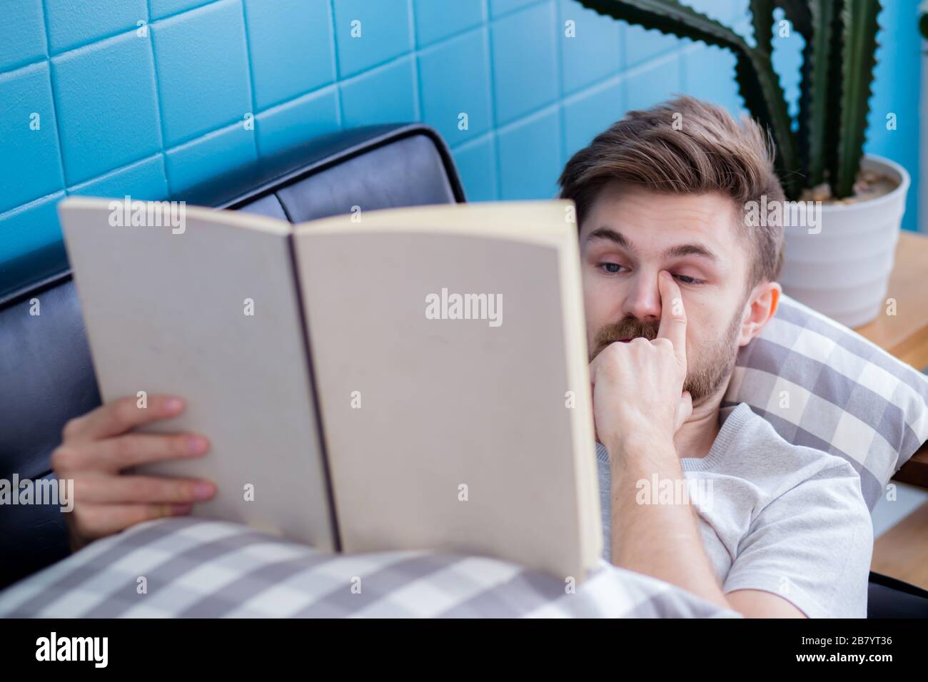 relax man reading a book lying on sofa education concept Stock Photo ...