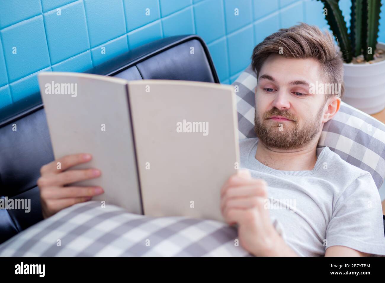 relax man reading a book lying on sofa education concept Stock Photo ...