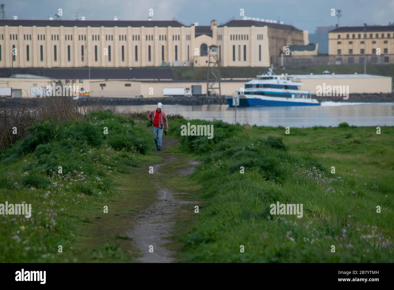 A man takes a walk in Corte Madera Marsh State Marine Park with San ...