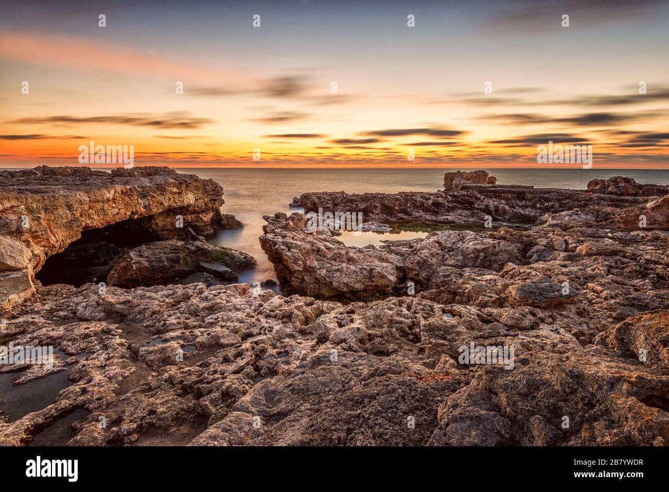 Beautiful dramatic sunrise on the rocky beach Stock Photo - Alamy