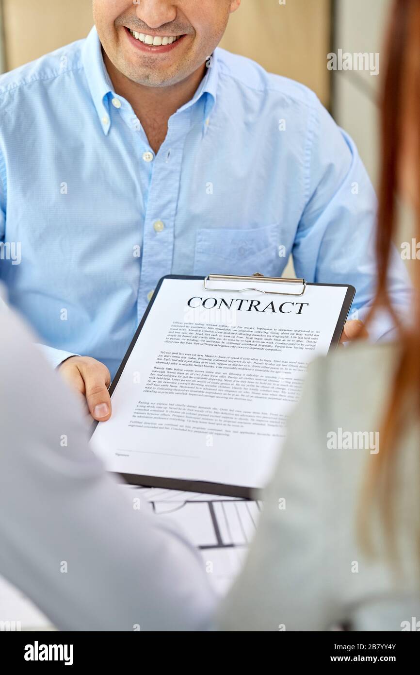 realtor showing contract document to customers Stock Photo - Alamy