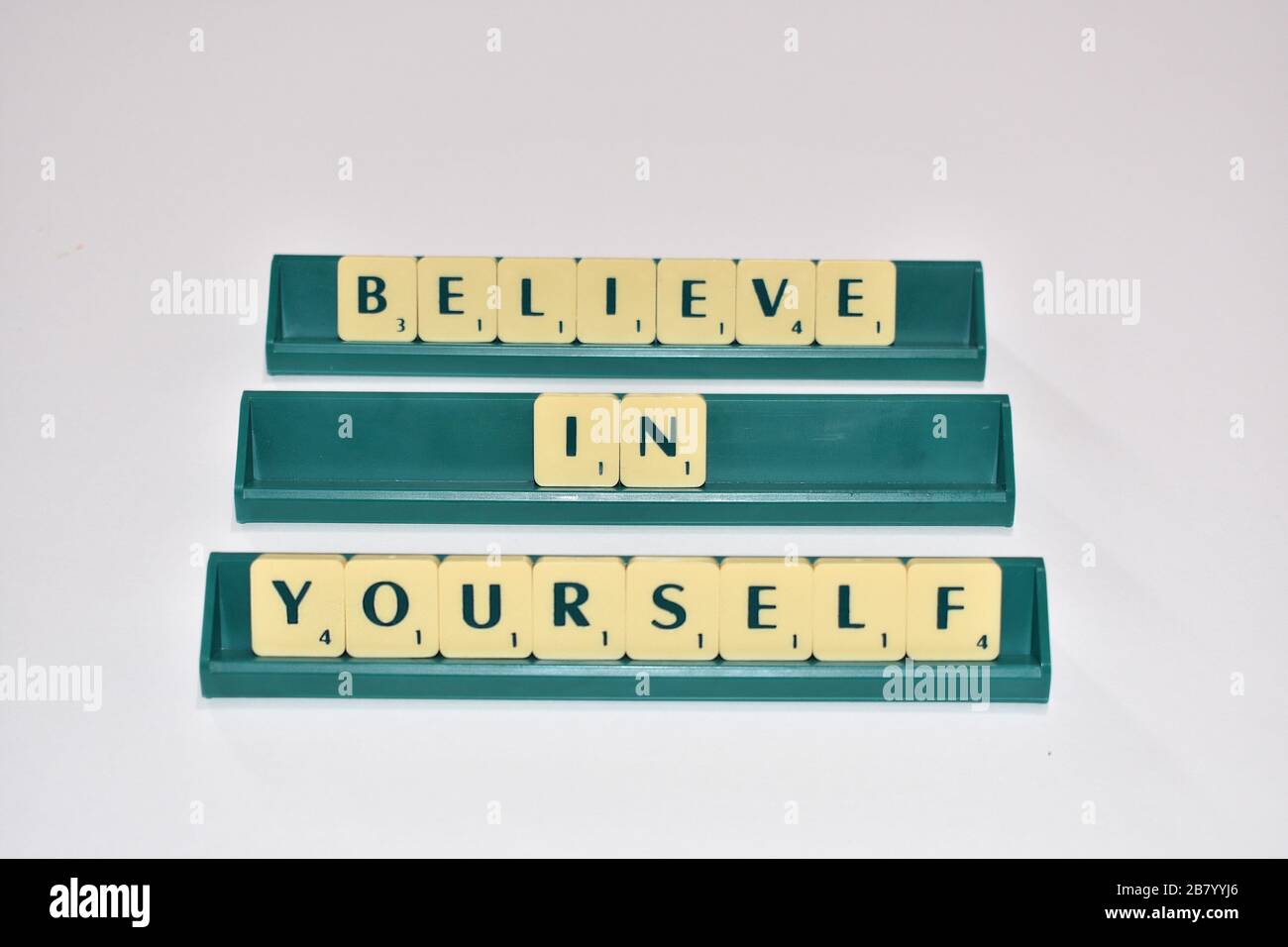 Scrabble tiles spell out Believe in Yourself. Motivational quote ...