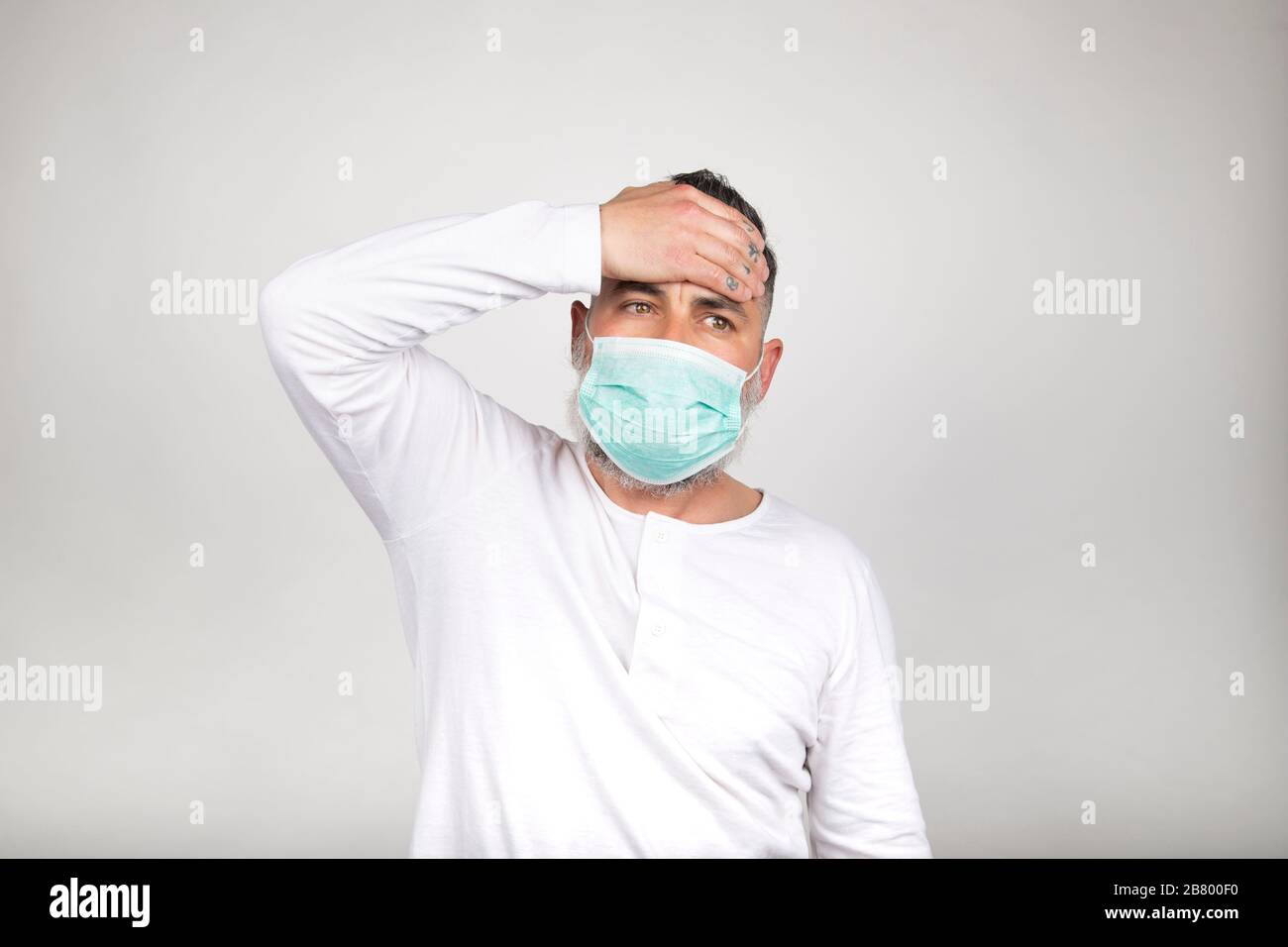 Sick man with medical mask presenting headache and fever, symptoms of ...