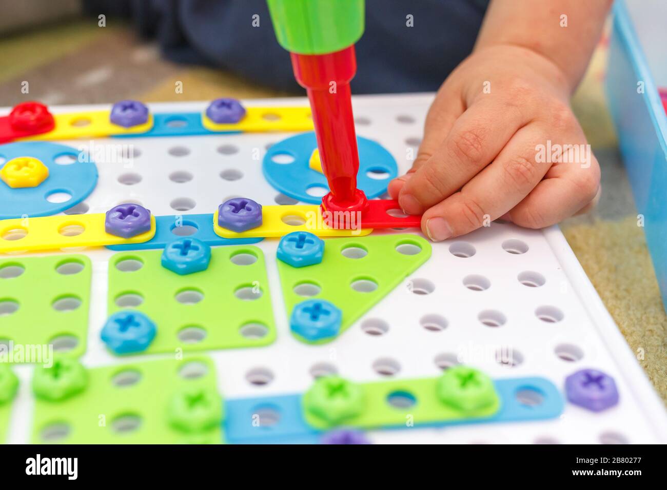 Kid learning to use screwdriver. Multicolor screws. Future occupation ...