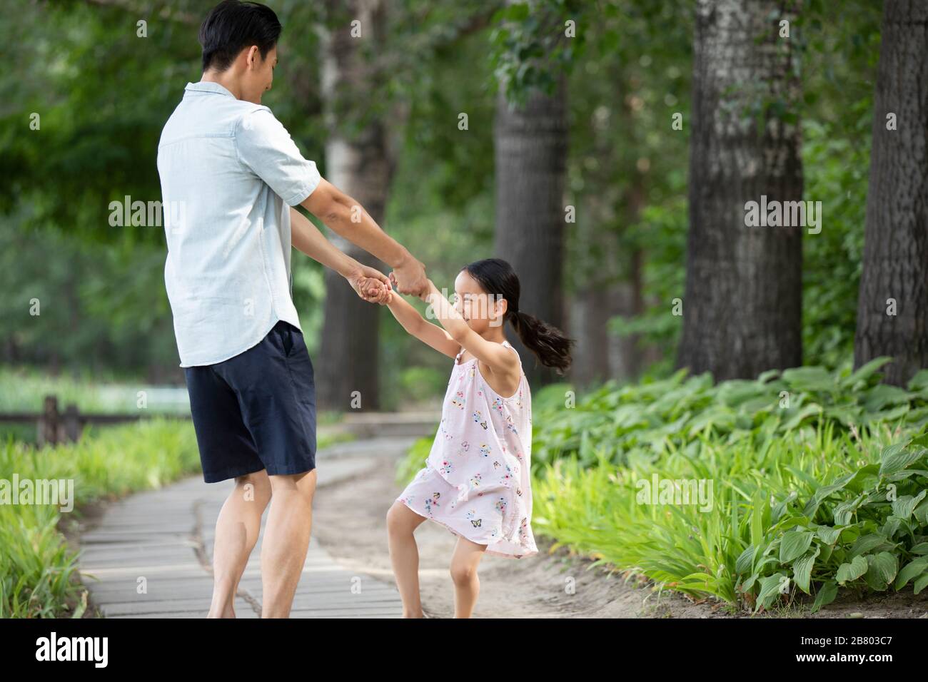 Happy Chinese father and daughter playing in park Stock Photo - Alamy