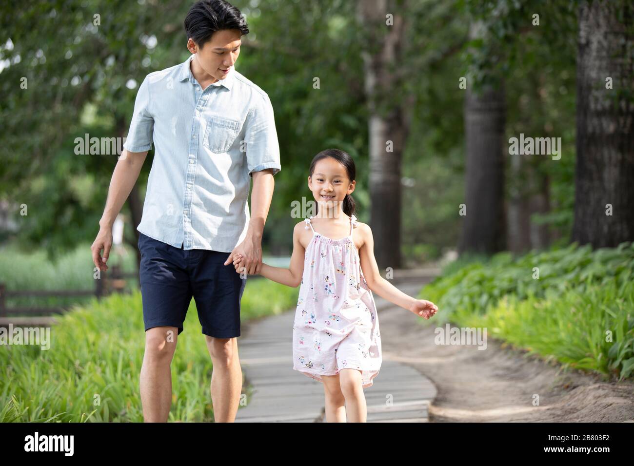 Happy Chinese father and daughter walking in park Stock Photo - Alamy