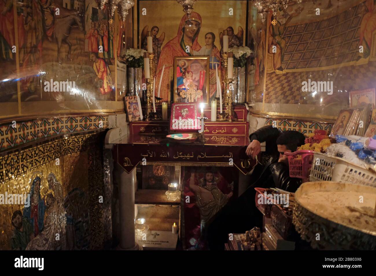 A Coptic Orthodox priest sits inside the small Coptic Chapel in the rear of the Aedicula of the ...