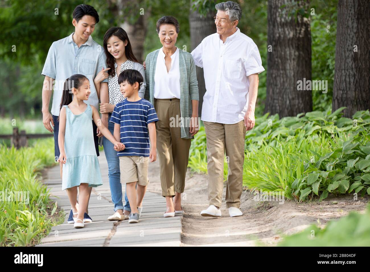 Happy Chinese family walking in park Stock Photo - Alamy