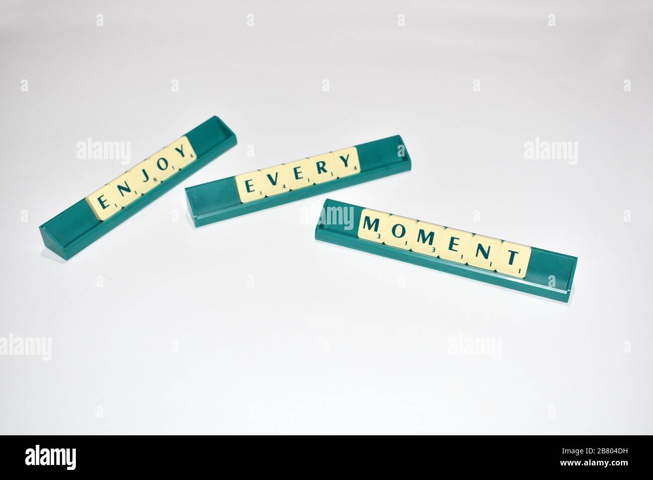 Scrabble tiles spell out Enjoy Every Moment. Motivational quote ...