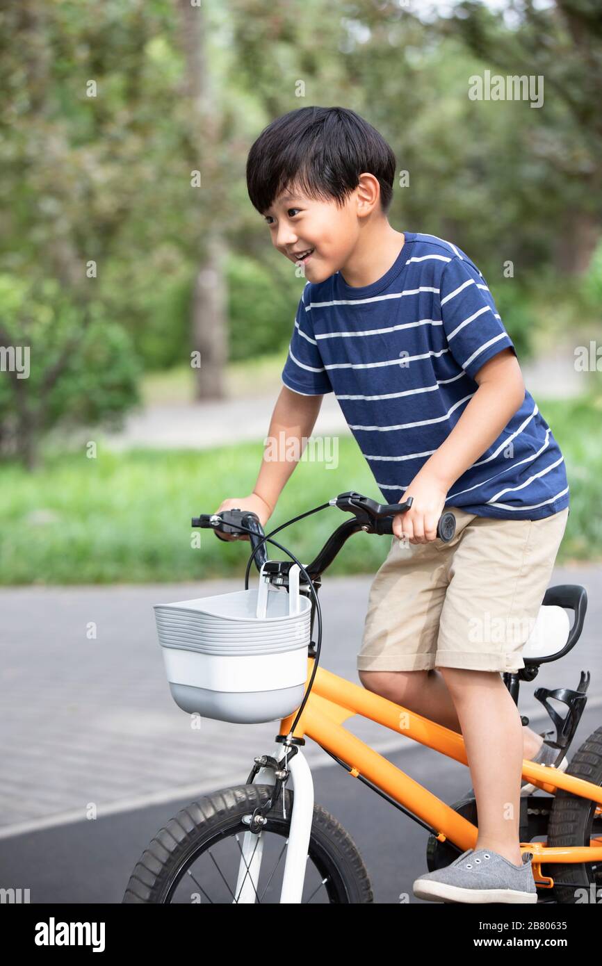 Boy in shorts riding bike hi-res stock photography and images - Alamy