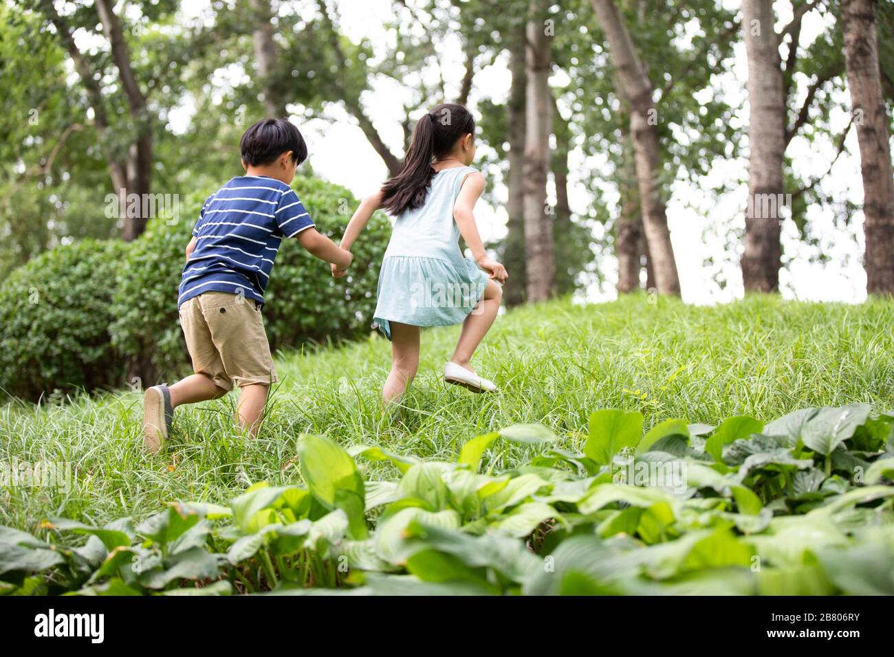Two Chinese children running on grass Stock Photo - Alamy