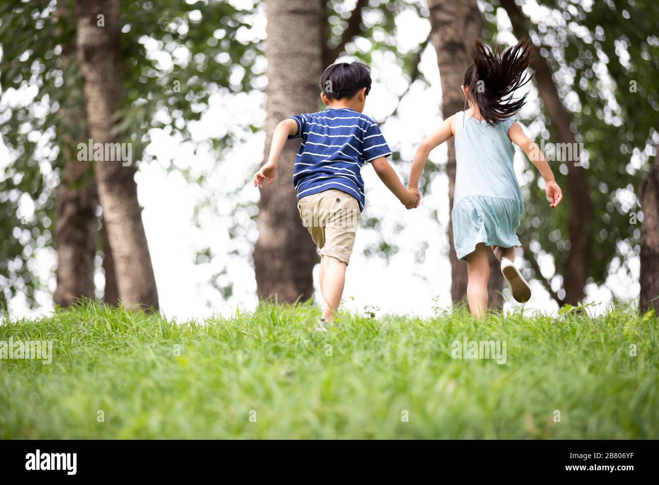 Two Chinese children running on grass Stock Photo - Alamy