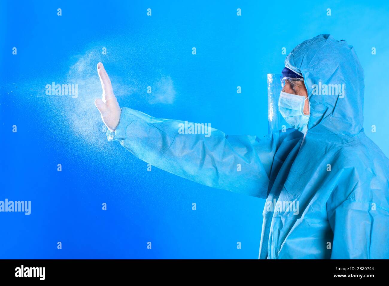 man in a blue full protected suit with disinfectant , conavirus ...