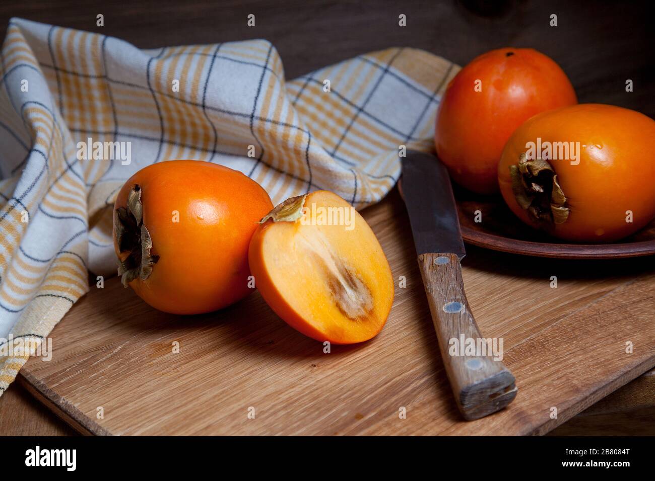 Composition of ripe delicious whole persimmon fruits, half and sliced ...