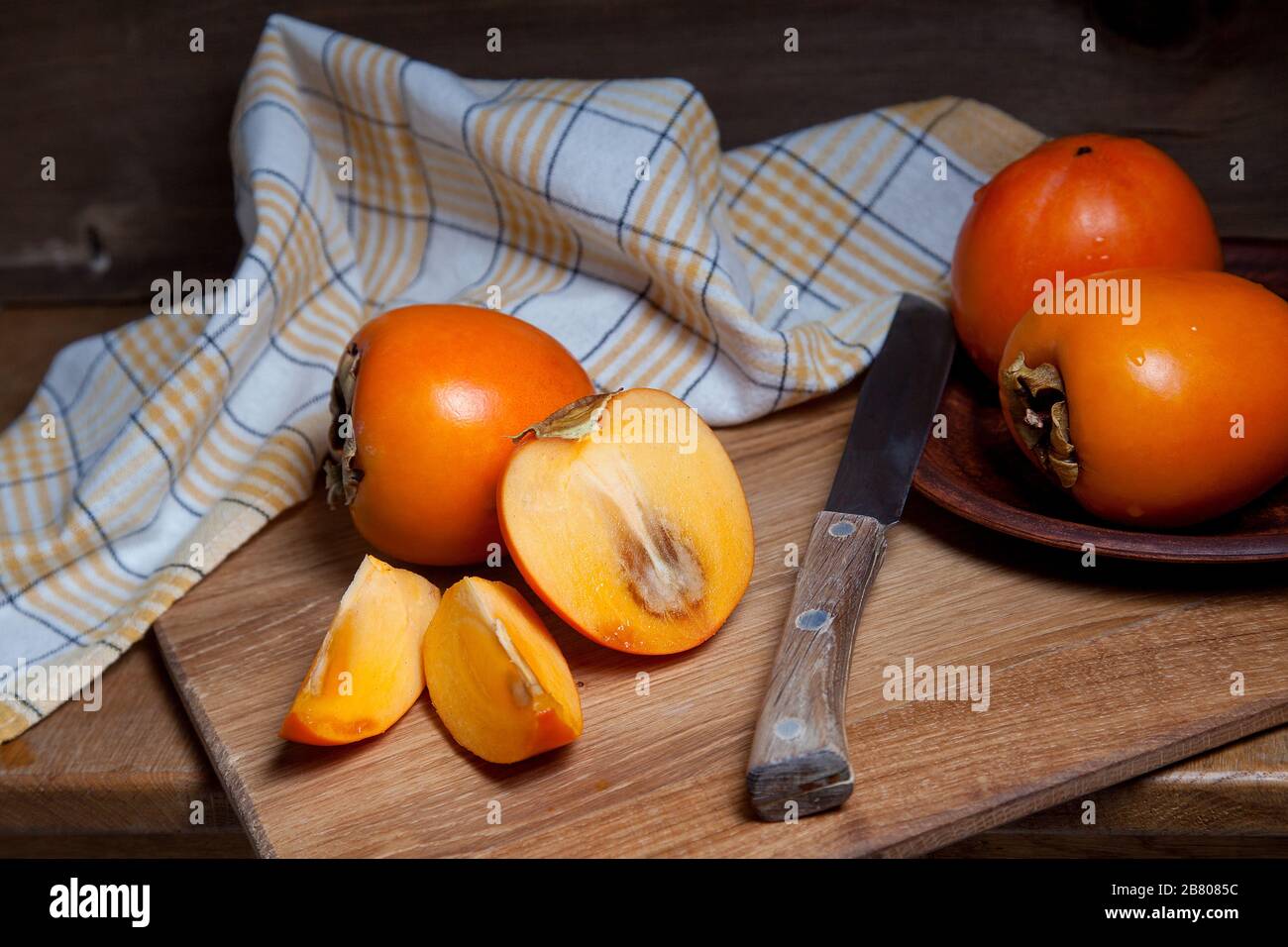Composition of ripe delicious whole persimmon fruits, half and sliced ...