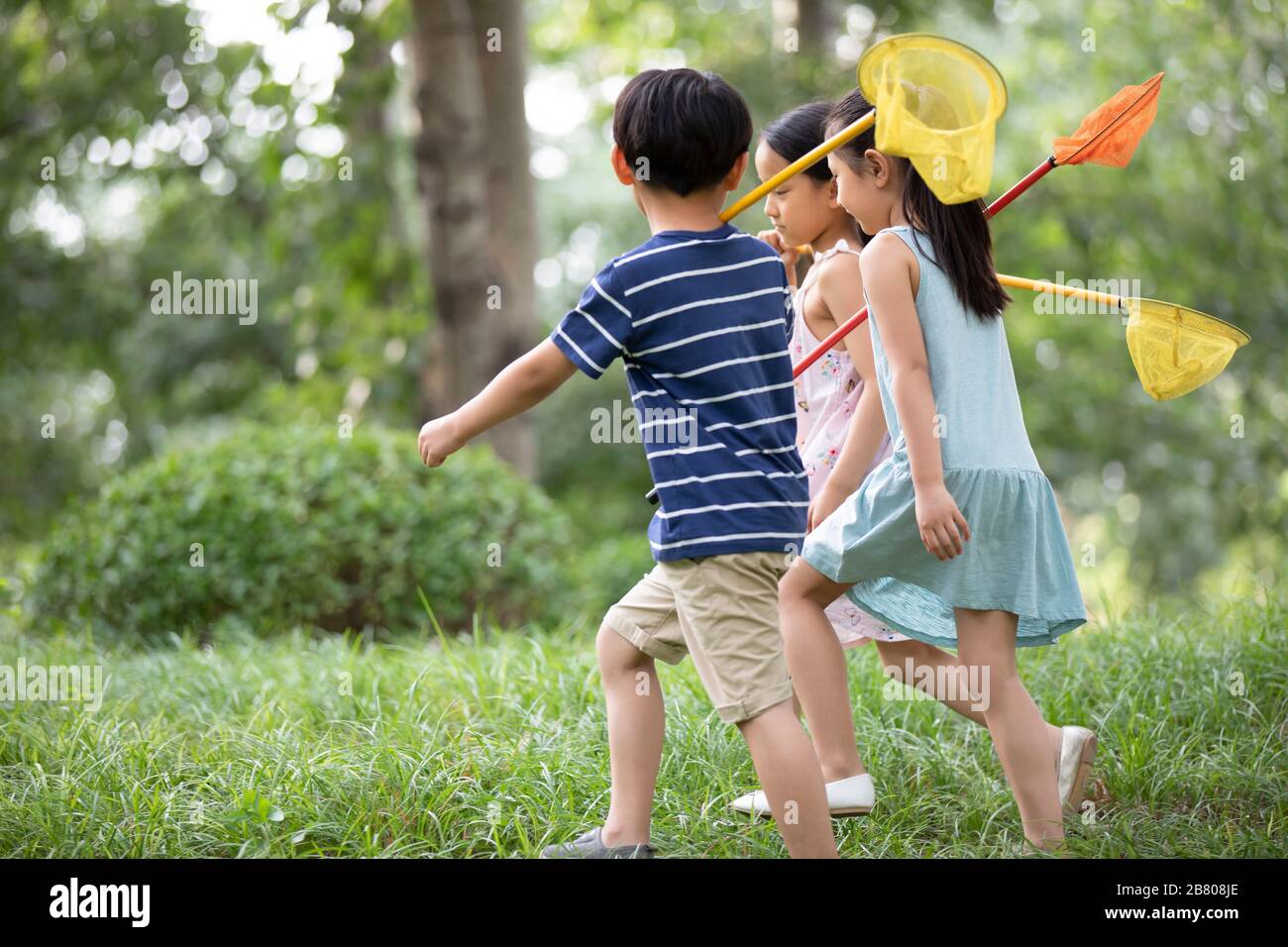 Three Chinese children playing on grass Stock Photo - Alamy