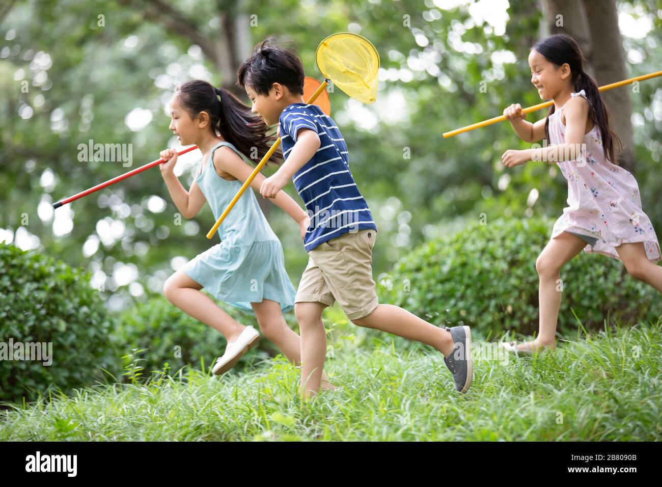 Three Chinese children playing on grass Stock Photo - Alamy