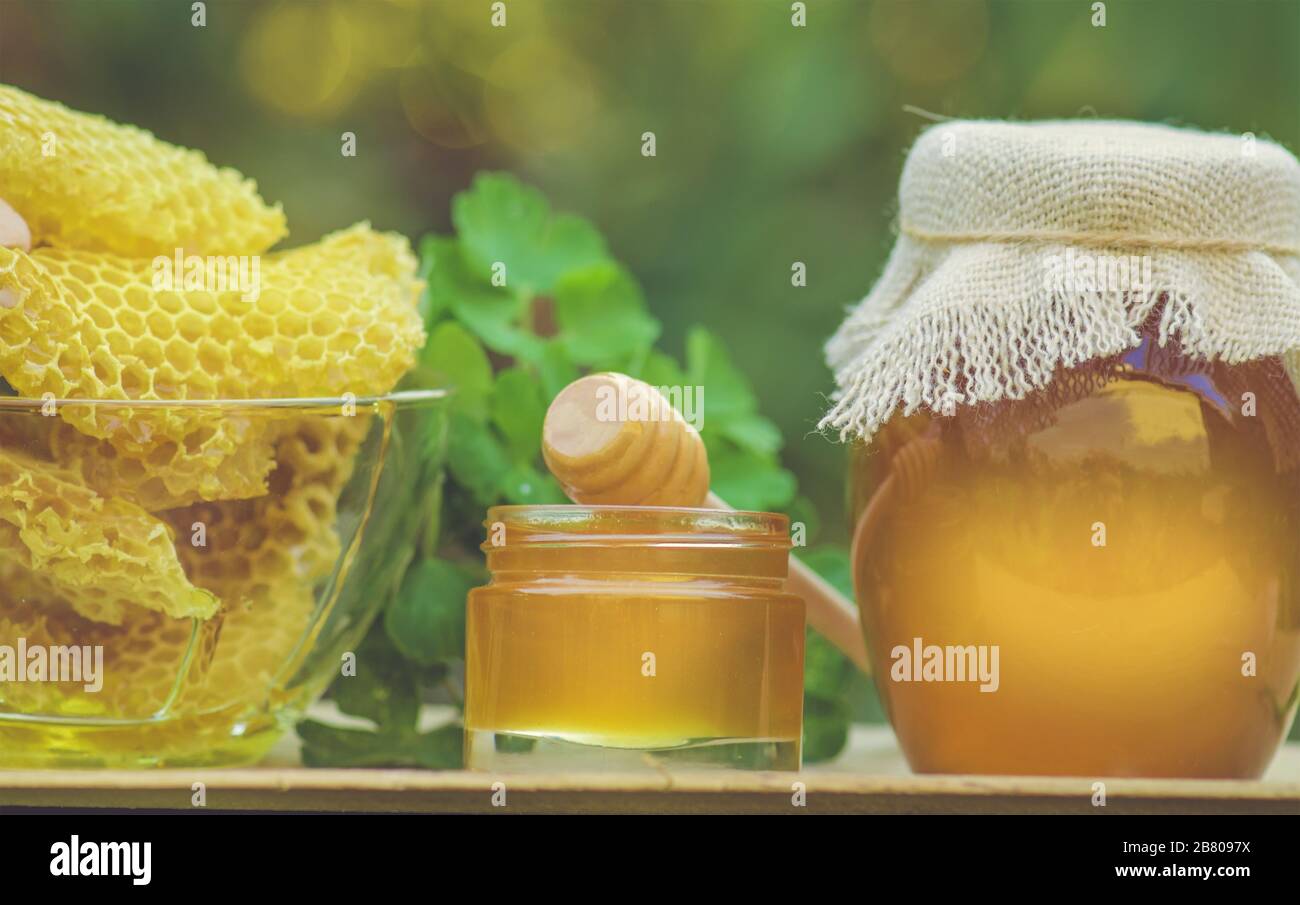 Honey in jar with honey dipper on rustic wooden table background. Sweet ...