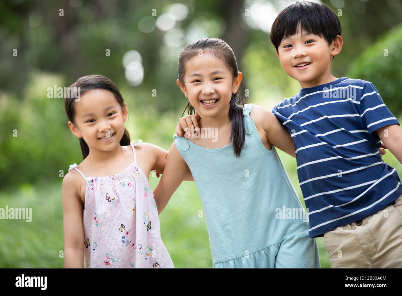 Three Chinese children playing on grass Stock Photo - Alamy