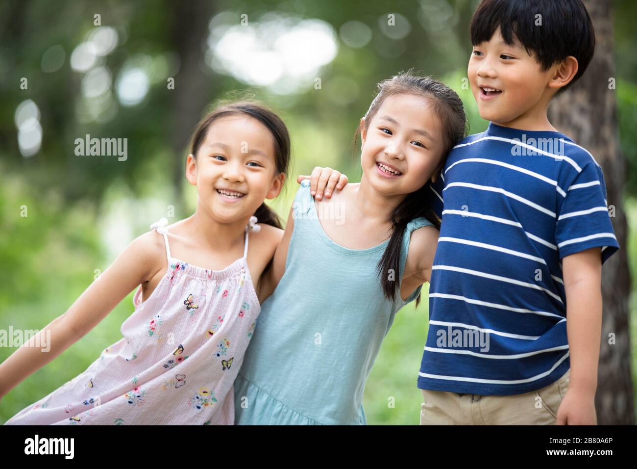 Three Chinese children playing on grass Stock Photo - Alamy