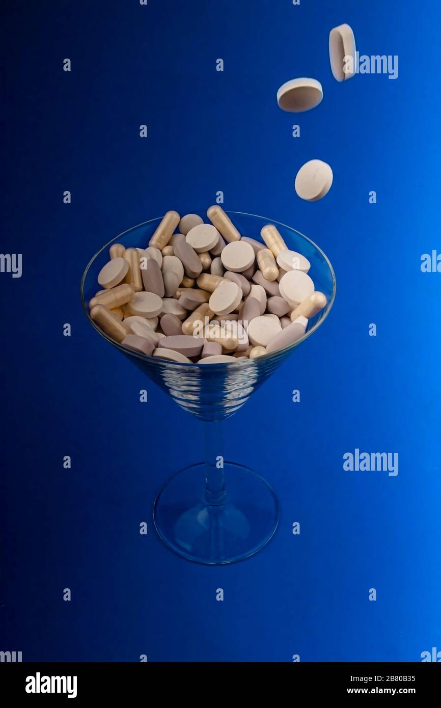 Falling white pills, tablets capsule on blue backround. Anti gravity ...