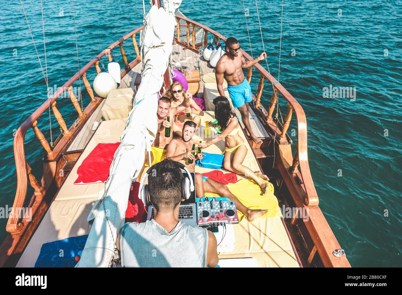 Group of young people dancing in sailing boat party with dj playing ...