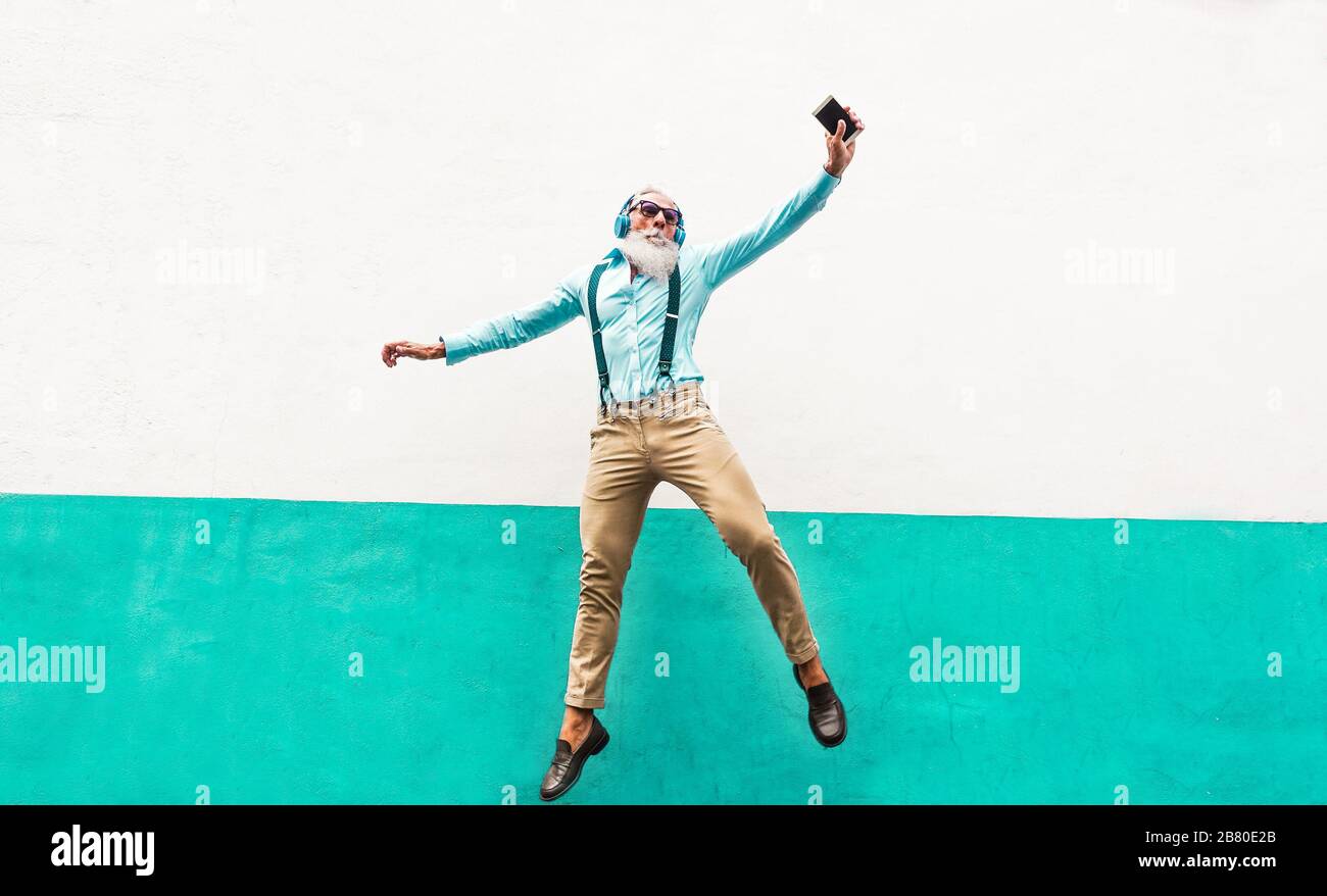 Crazy senior man jumping and listening music outdoor - Happy mature ...