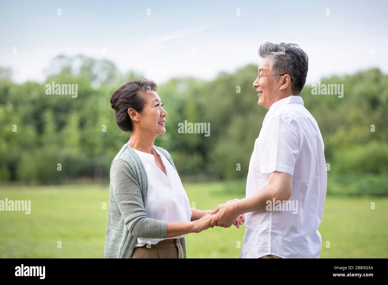 Happy senior Chinese couple holding hands on grass Stock Photo - Alamy