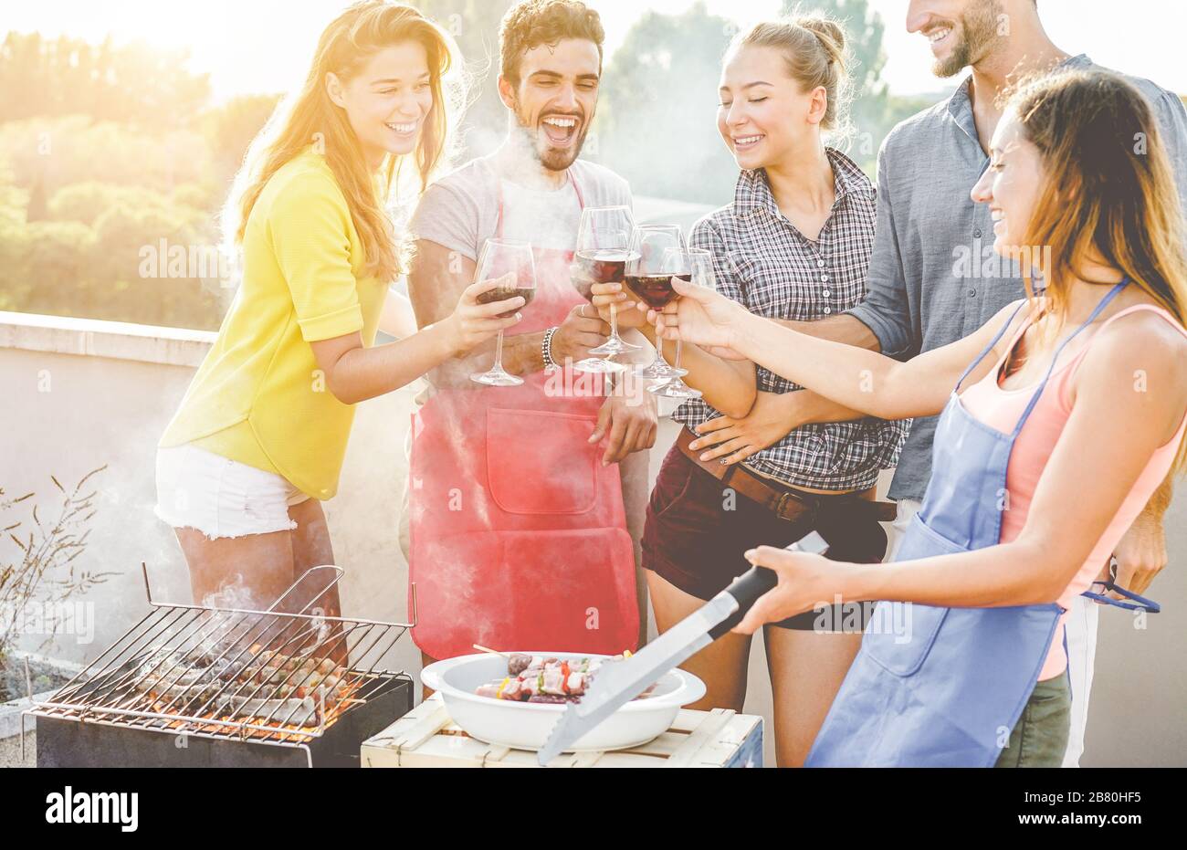 Happy friends cheering with red wine at barbecue dinner party - Young ...